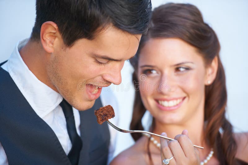 Reception Fun A Young Bride Feeding Her New Husband Wedding Cake And Smiling Stock Image