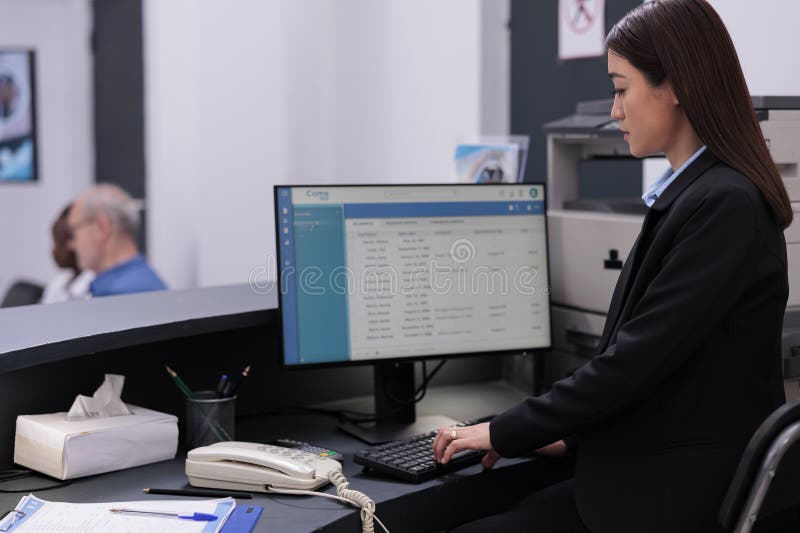 Reception Worker Checking Patient Examination Report on Computer ...