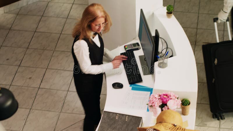 Receptionist Doing Check in Process Stock Video - Video of receptionist ...