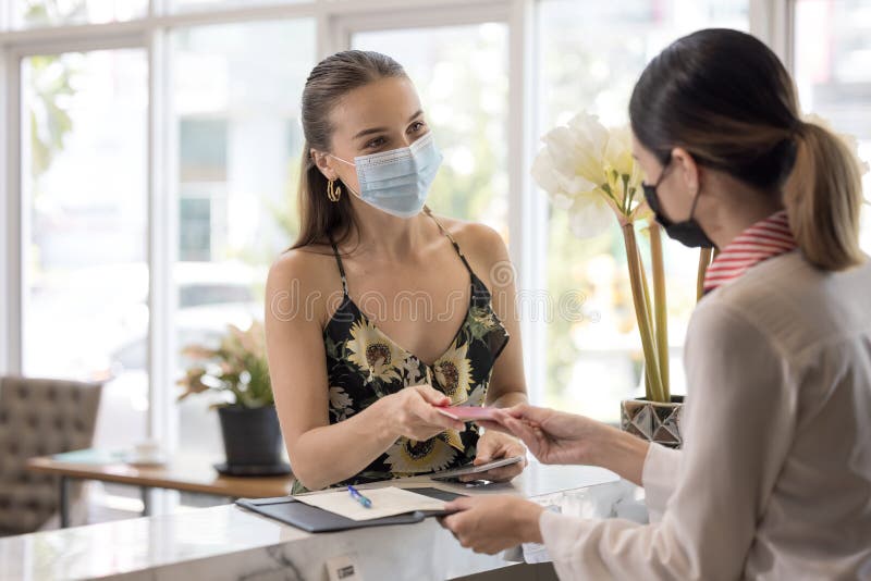 Receptionist Hands Over a Passport To a Tourist at Te Front Desk and ...