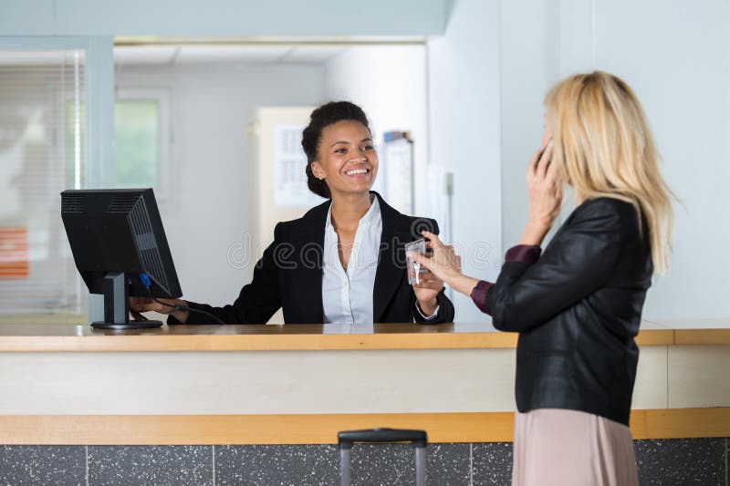 Receptionist at Hotel Reception Smiling To Female Customer Stock Photo ...