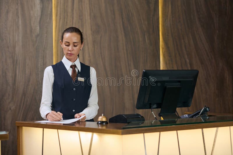 Receptionist Signing Documents Behind the Reception Desk Stock Photo ...