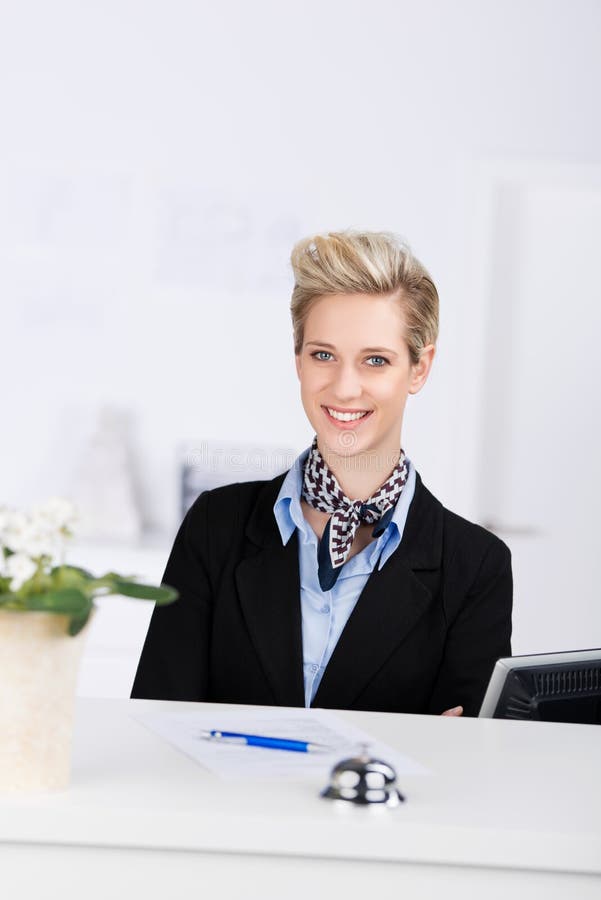 Receptionist Smiling at Desk Stock Photo - Image of check ...