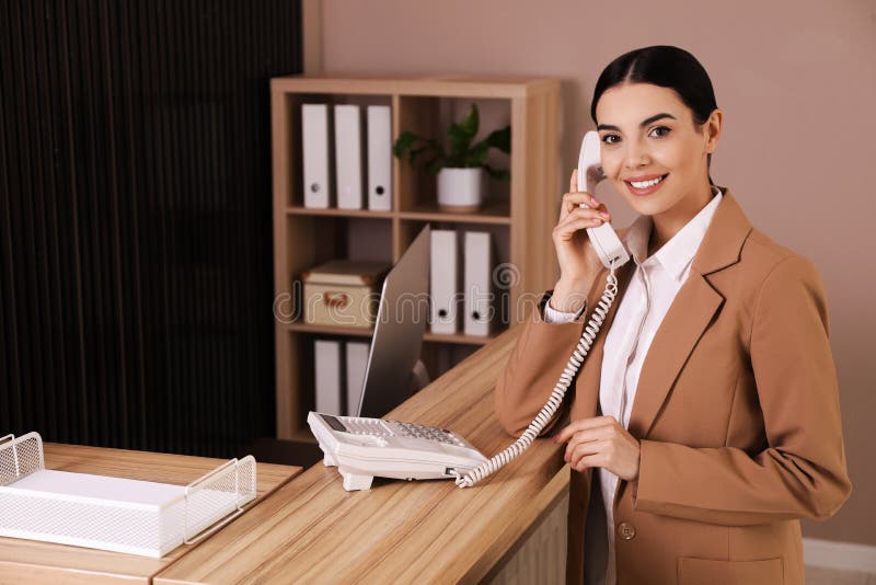 Receptionist Talking on Phone Near Countertop in Office Stock Photo ...