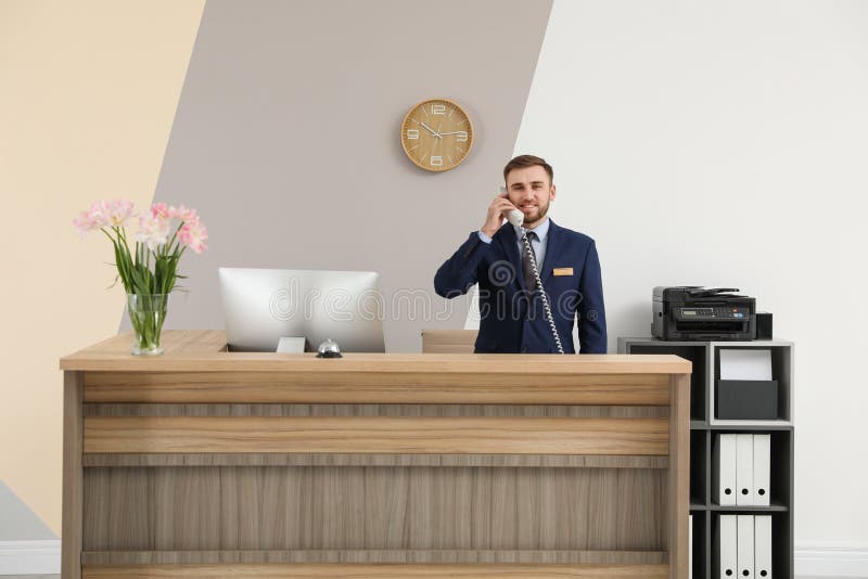 Receptionist Talking on Telephone at Desk Stock Photo - Image of office ...