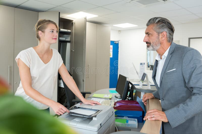 Receptionist Talking To Client while Making Photocopies Stock Image ...