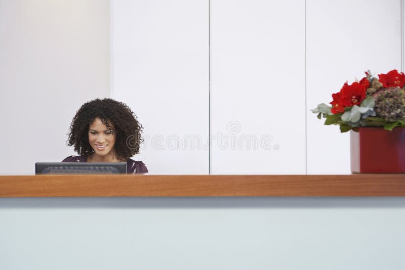 Receptionist Using Computer at Reception Desk Stock Photo - Image of ...