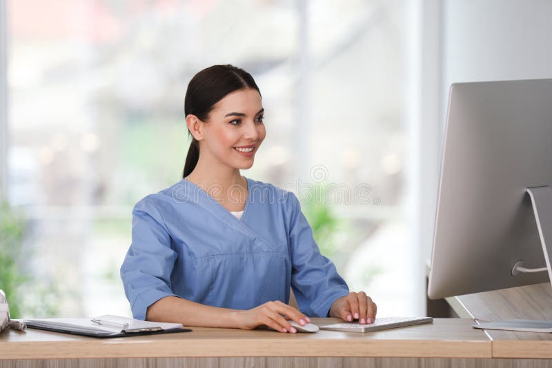 Receptionist Working with Computer at Countertop Stock Photo - Image of ...