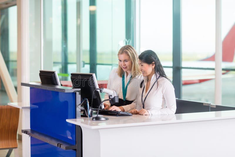 Receptionists Using Computer while Senior Business Couple Waitin Stock ...