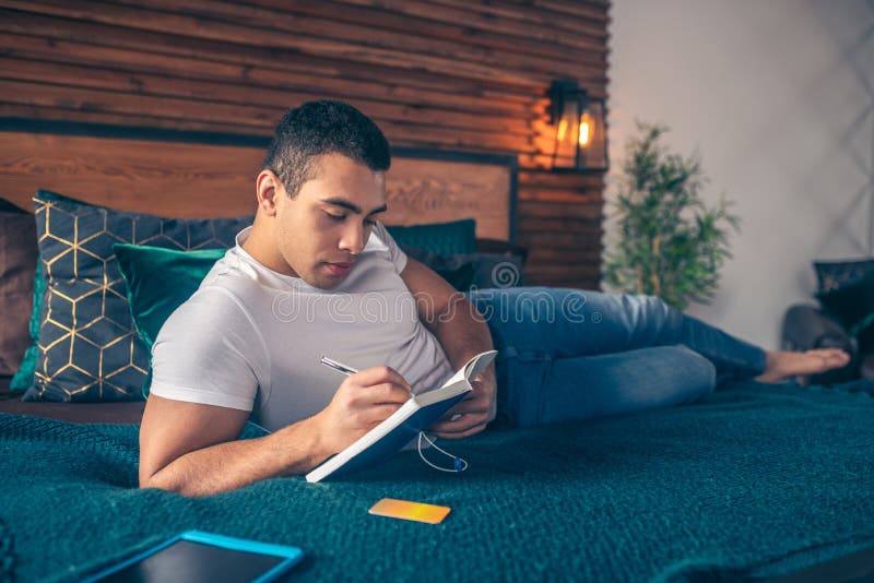 Writing Guy in a Notebook Lying on a Bed. Stock Image - Image of white ...