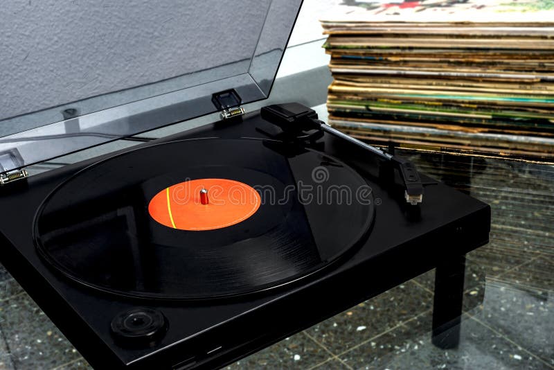 Record Player with a Vinyl Record Spinning with a Stack of Vinyls ...