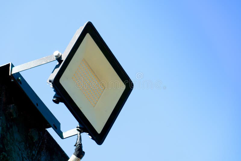Rectangular Outdoor Floodlight Mounted on a Bracket Against a Clear ...