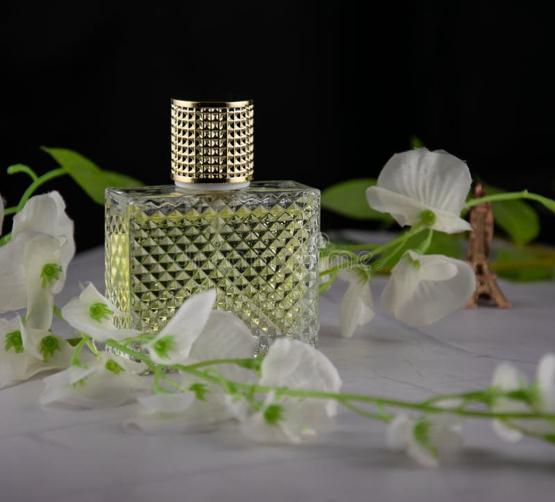 A Rectangular Perfume Bottle on a Marble Background with White Flowers ...
