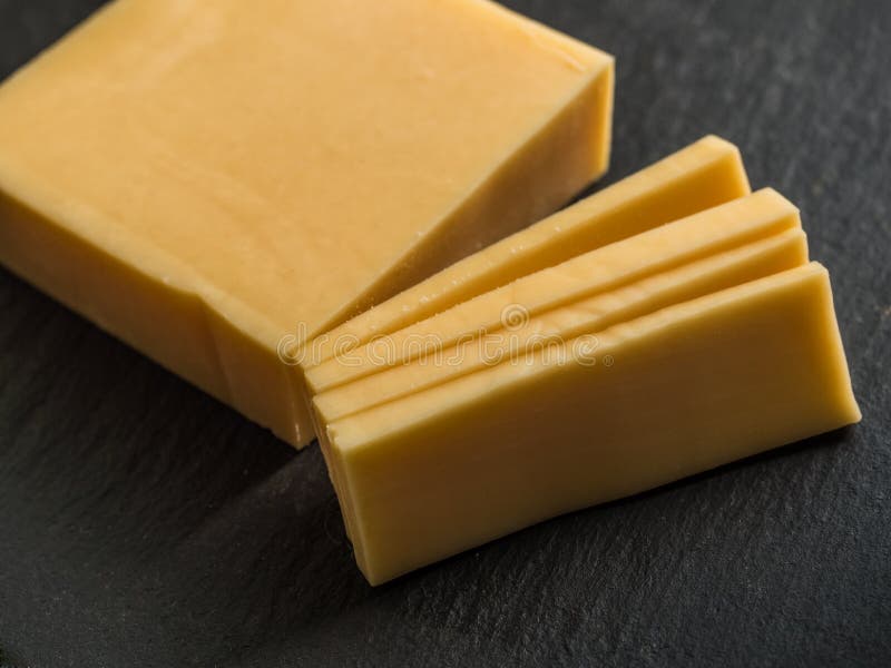 Rectangular Sliced Parmesan Cheese on a Black Slate Cutting Board ...
