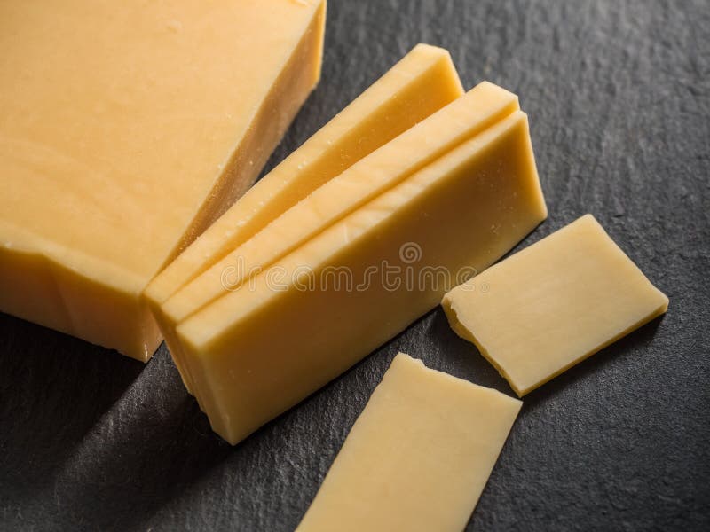 Rectangular Sliced Parmesan Cheese on a Black Slate Cutting Board ...