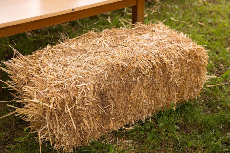 Rectangular Straw Bale on Grass Next To Wooden Bench in Outdoor Setting ...