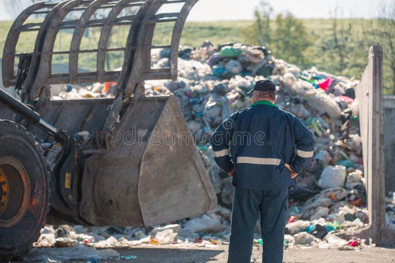 Recycling Center Worker Looking at an Unsorted Garbage Heap, Rear View ...