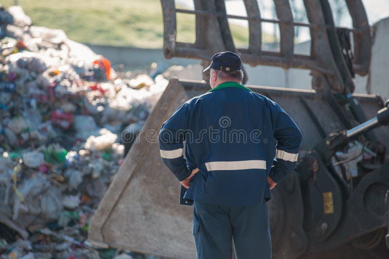 Recycling Center Worker Looking at an Unsorted Garbage Heap, Rear View ...