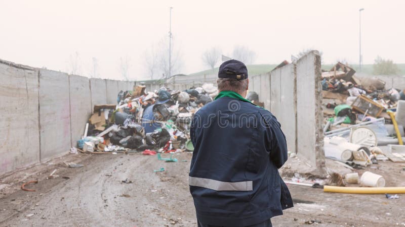Recycling Center Worker Looking at an Unsorted Garbage Heap, Rear View ...