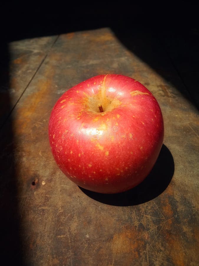 Red Apple in the Middle of Vintage Table with Light Reflection Stock ...