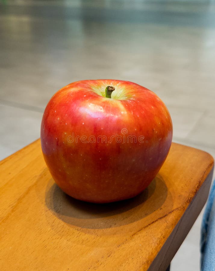 A Red Apple Sitting on a Wooden Bench Top Stock Image - Image of flower ...