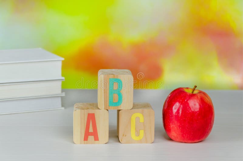Red Apple, Stack of Books and ABC Cubes on Desktop on Blurred Autumn ...