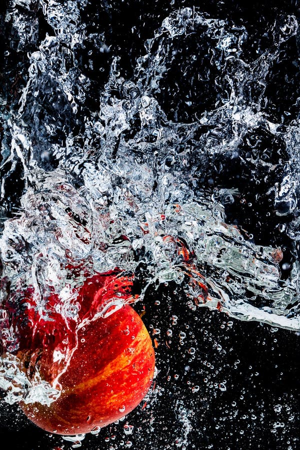 Red Apple Thrown into Water with Splash and Black Background Stock ...
