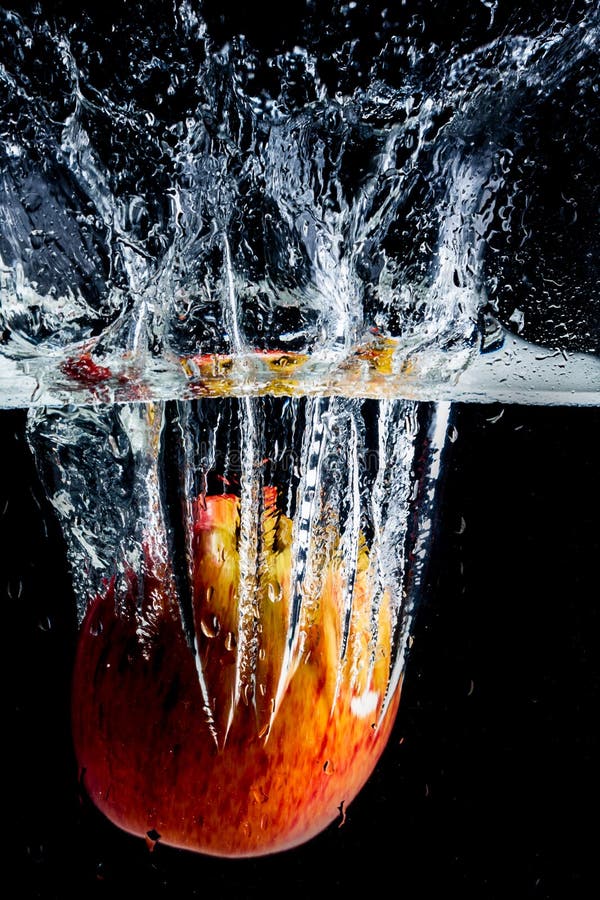 Red Apple Thrown into Water with Splash and Black Background Stock ...
