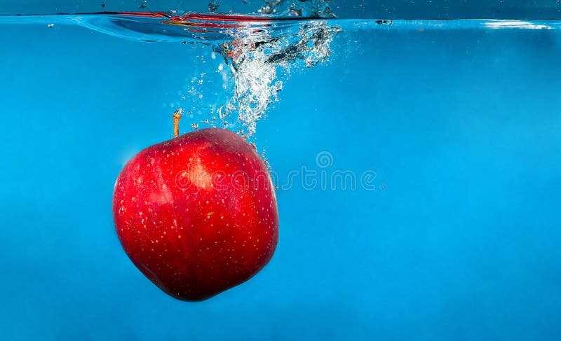 Red Apple in Water with Splash and Drops Over Blue Stock Photo - Image ...