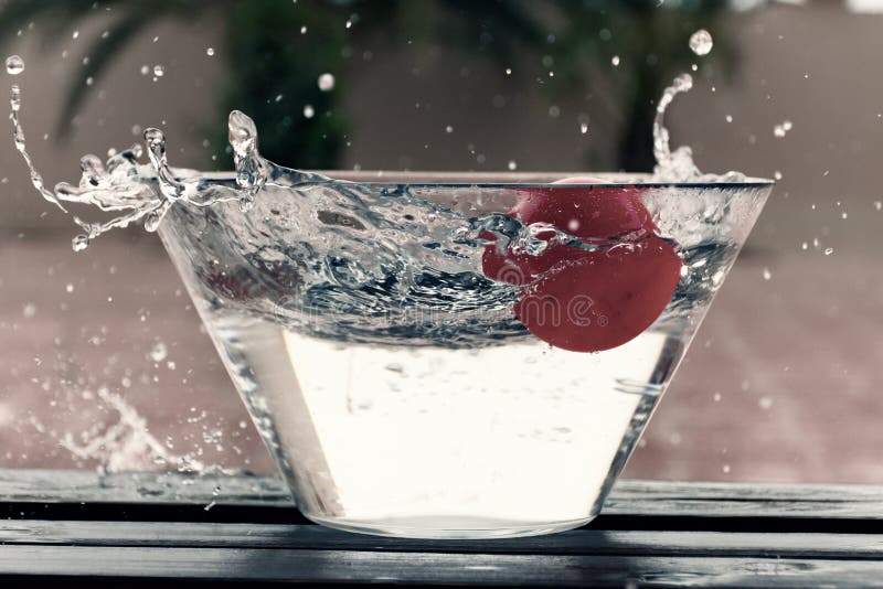 Red Ball Splashing in a Clear Bowl of Water Creating Patterns and ...