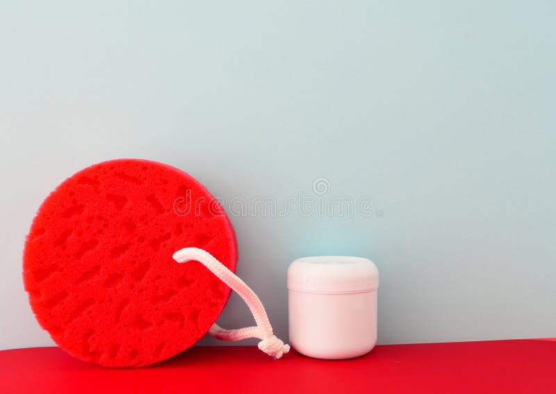 Red Bath Sponge and a White Cream Box on a Light Blue and Red ...