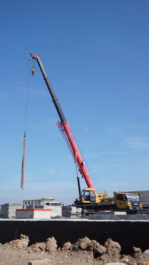 Red Black Crane and Yellow Truck on a Construction Site Editorial ...