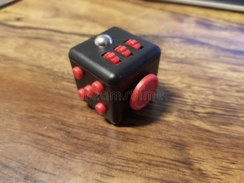 Red and Black Fidget Cube Sitting on a Table Stock Photo - Image of ...