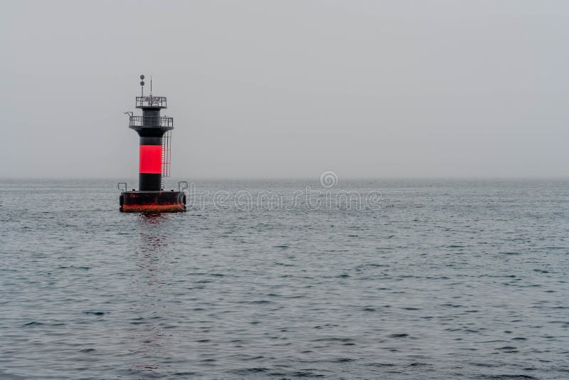Red and Black Lighthouse Offshore Stock Photo - Image of hazy, port ...
