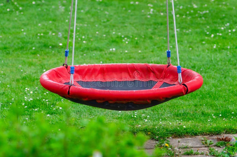 Red and Black Saucer Swing in Backyard Stock Photo - Image of child ...