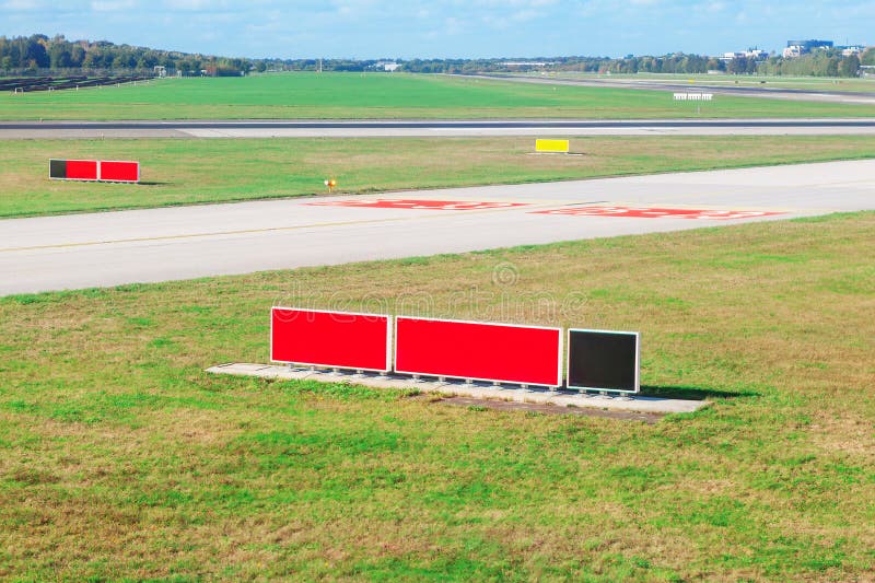Red and Black Sign is on the Grass Next To a Runway Stock Image - Image ...