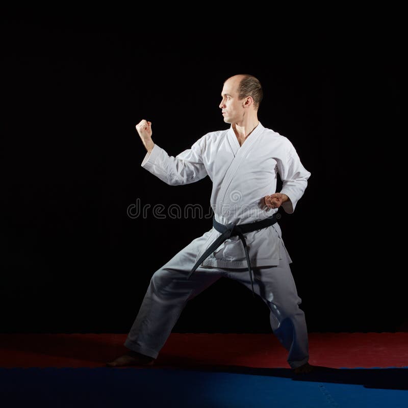 On Red and Blue Tatami Active Athlete Performs Formal Karate Exercises ...