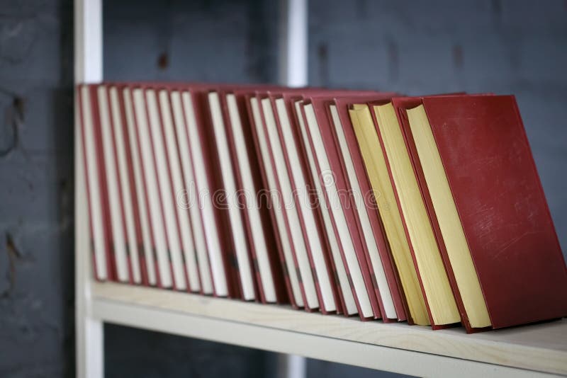 Red Books are on the Shelf Near the Gray Wall Stock Image - Image of ...