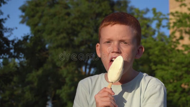 Red boy eating popsicle stock footage. Video of urban - 294131206