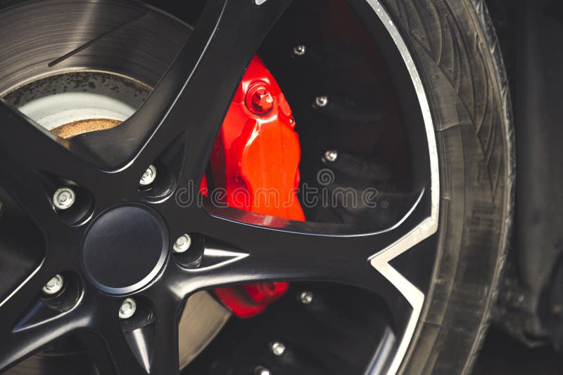 Red Brake Pads and Discs of Modern Car with Black Alloy Discs. Stock ...