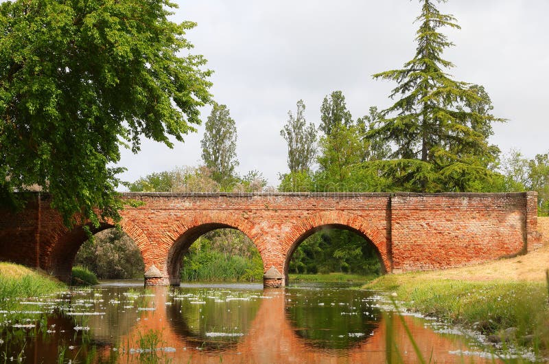 Red Brick Bridge with Visible Masonry and the Reflection of Its Three ...