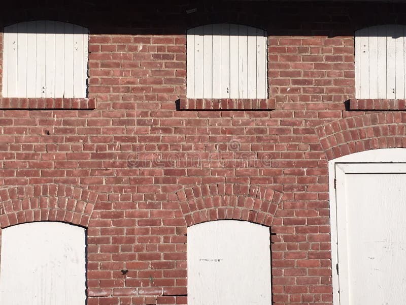 Red Brick Wall with Three Boarded Up Rectangular Windows and Three ...