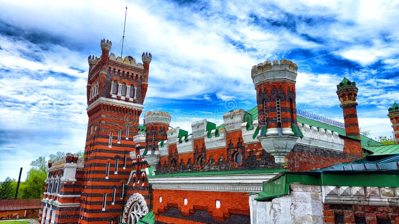 A Red Brick Castle with Green Roofs and a Tall Tower Under a Bright ...