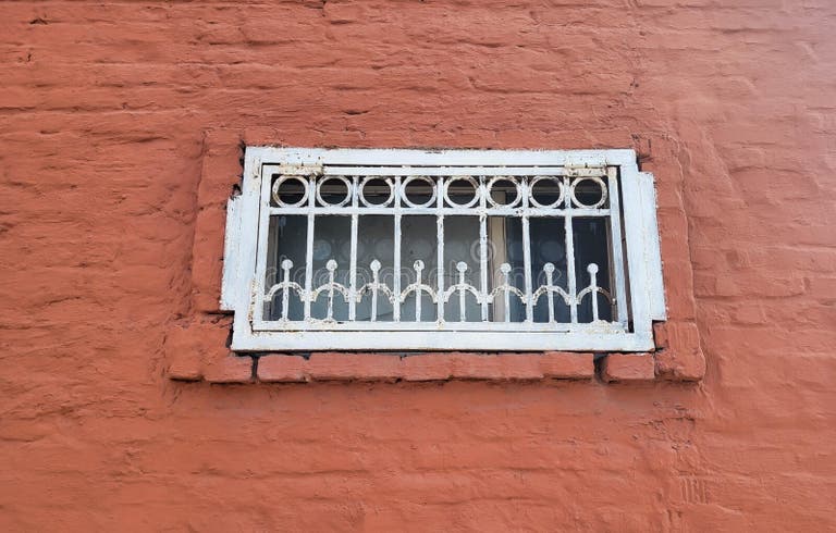 On the Red Brick Facade There is a Small Rectangular Window with a ...