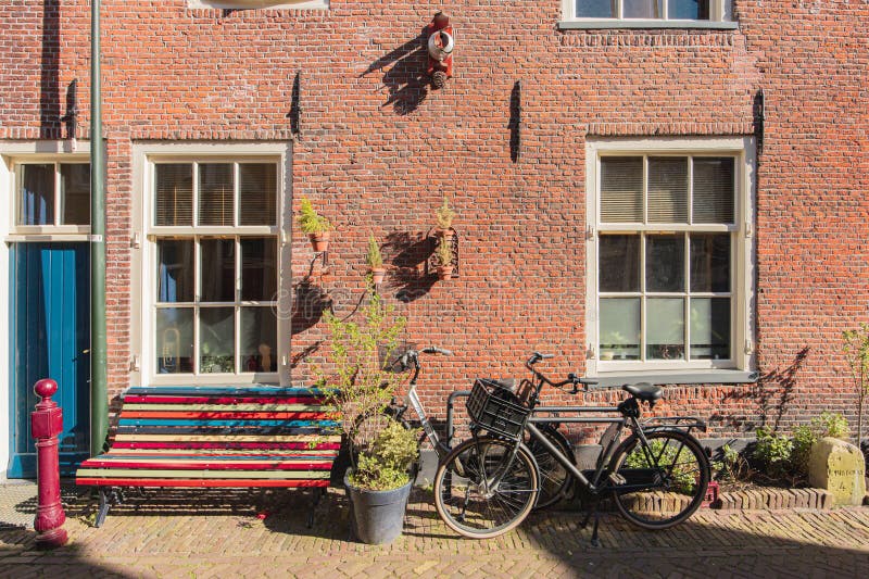 A Red Brick House Wall, with a Bench and a Bicycle in Front of it, in ...