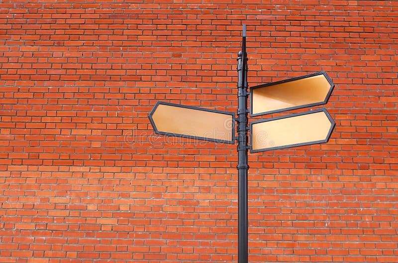 At the Red Brick Wall is an Iron Column with Arrows Stock Image - Image ...