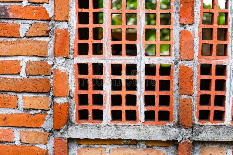 Red Brick Wall with a Section Featuring a Grid-like Pattern of Small ...