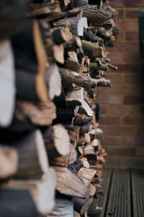 Red Brick Wall with a Tree Log Stack in the Foreground Stock Photo ...