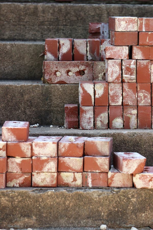 Red Bricks Stacked on Concrete Steps, Vertical Stock Photo - Image of ...