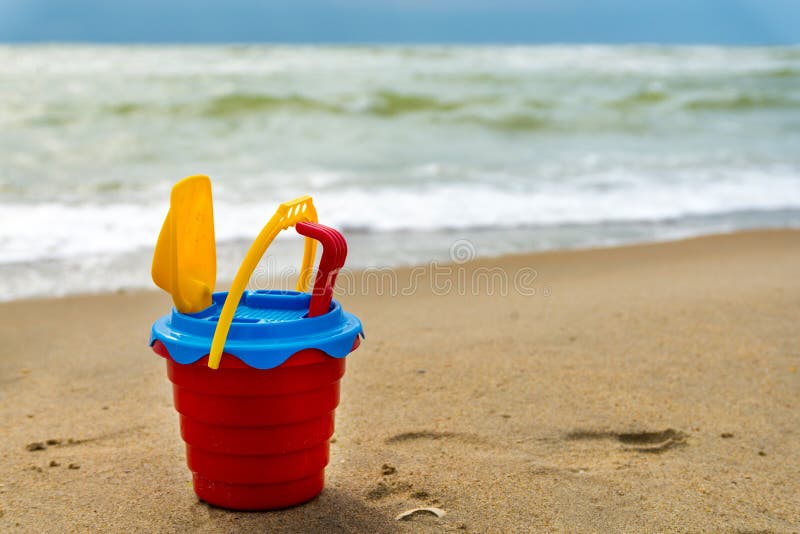 Red Bucket with a Shovel, a Rake and a Net on the Beach Stock Image ...